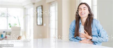 집에서 흰색 테이블에 앉아 미소와 재미 미친 농담 때문에 큰 소리로 웃 고 아름 다운 젊은 여자의 광각 사진 행복 한 표현 가정 생활에 대한 스톡 사진 및 기타 이미지