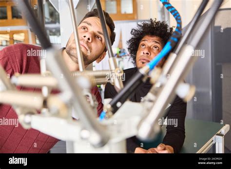 Engineers Programming And Inspecting Robotic Arms In A High Tech Facility Focused On Industrial