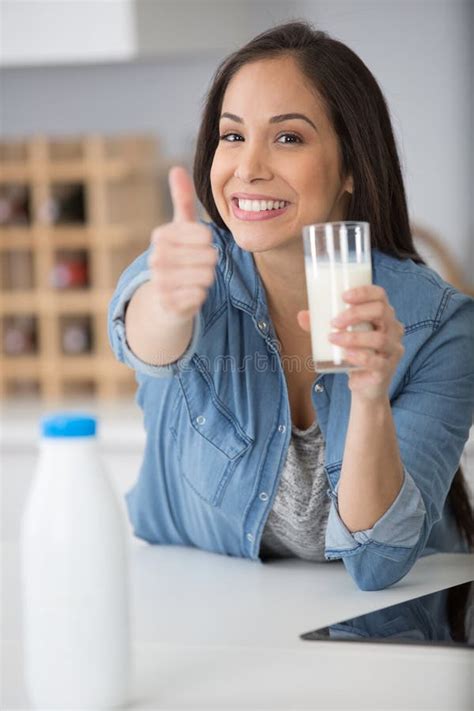 Mujer Feliz Bebiendo Los Pulgares De La Leche De Vidrio Imagen De Archivo Imagen De Elegante