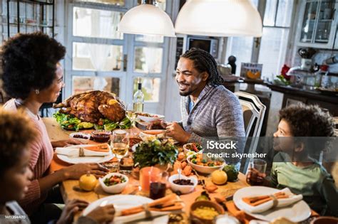 식탁에서 추수 감사절 식사 중 말하는 행복한 아프리카 계 미국인 가족 구이 디너에 대한 스톡 사진 및 기타 이미지 구이 디너 추수감사절 가정 생활 Istock