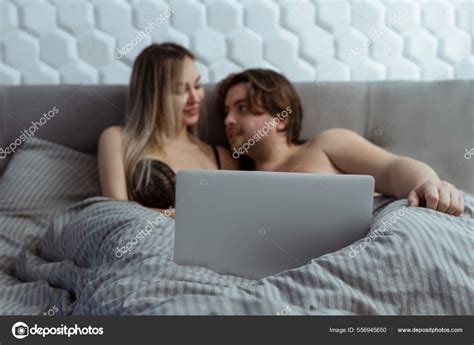 Couple Watching Porn Movie Over Laptop In Bedroom Stock Photo Redjy R