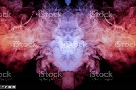 유령 머리의 형태로 신비한 모양의 보라색과 파란색 연기의 멀티 컬러 패턴 또는 검은 고립 된 배경에 이상한 생물 파도와 증기의 추상 패턴입니다 개념에 대한 스톡 사진 및
