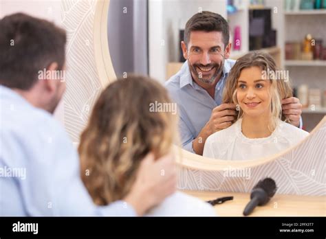 Male Hairdresser In Discussion With Female Client Looking In Mirror