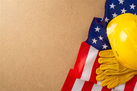 노동절 개념에 대한 핸디맨 필수품 안전 장갑 헬멧과 같이 근로자가 일반적으로 사용하는 도구의 평면도는 미국 국기와 함께 나무