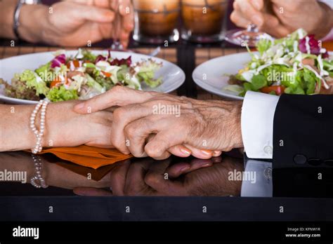 Hand Of An Mature Man Touching The Hand Of An Mature Woman At Dinner Stock Photo Alamy