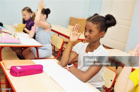 어린 아이들은 미소를 지으며 여성 교사와 학교 수업의 배경에 대한 응답을 위해 손을 잡고 있습니다 스쿠로 돌아가기 교사 교육 관련 직업에 대한 스톡 사진 및 기타 이미지