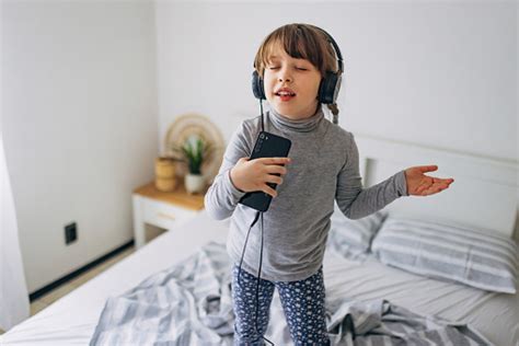 한 소녀가 침실의 침대에 서서 눈을 감고 노래를 부르고 음악을 듣는다 노래에 대한 스톡 사진 및 기타 이미지 노래 아이 4 5세 Istock