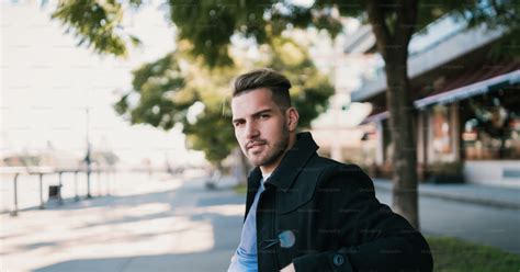 겨울 옷을 입고 거리의 벤치에 앉아 있는 젊은 남자의 초상화 도시 개념 사진 Unsplash의 의류 이미지