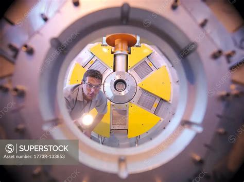 Scientist Inspects Particle Accelerator Superstock