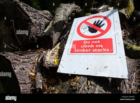 A Warning Sign Telling The Public Not To Climb On The Dangerous Pile Of Logs Stock Photo Alamy