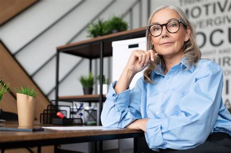 Premium Photo Business Woman Manager Years Old Sits At Her Desk And Looks Seriously At The