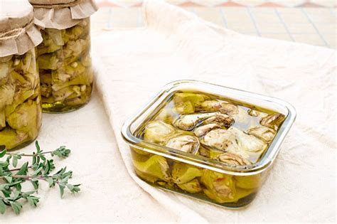 올리브 오일과 허브로 절인 아티 초크 하트 테이블 위의 유리 그릇에 마늘을 곁들인 절인 아티 초크 수제 건강한 식습관 저장하기에 대한 스톡 사진 및 기타 이미지 Istock