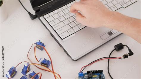 A Male Programmer Creates Robotics An Arduino Board Controls Servo