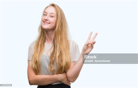 금발 십 대 여자 승리 표시를 하 고 카메라에 윙크 하는 행복 한 얼굴로 웃 고 두더지 셔츠를 입고 번호 2입니다 금발 머리에 대한 스톡 사진 및 기타 이미지 Istock