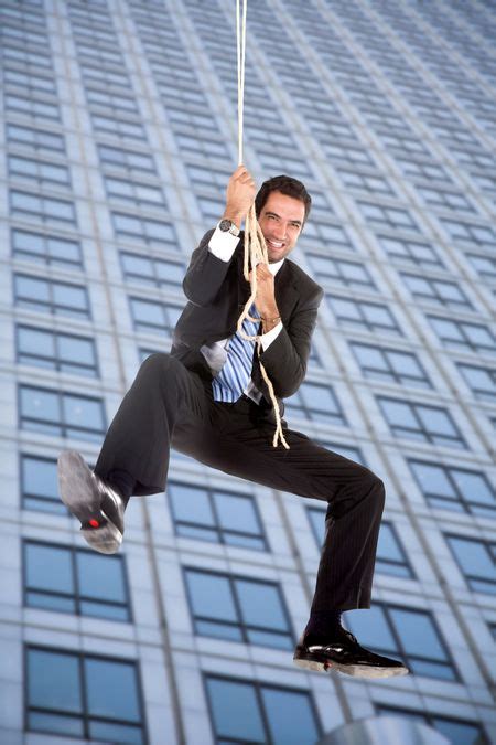 Business Man Jumping From A Building With A Rope Freestock Photos