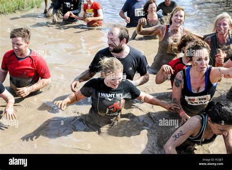 Runners Crossing Muddy Obstacles At Obstacle Course Race Uk Stock
