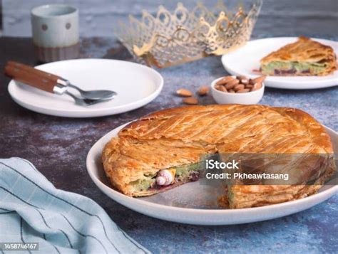 전통적인 프랑스 갈레트 데 루아 또는 킹 케이크 조각 케이크 안에 페브 왕관 아몬드를 배경으로 에피파니 케이크에 대한 스톡 사진