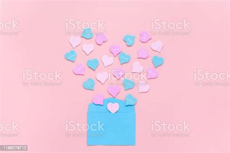 텍스트 사랑 키스 영원히 당신의 핑크 배경에 파란색 종이 봉투에서 마음의 형태로 날아 다채로운 마음 발렌타인 데이 컨셉 연인을위한 선물 사랑 고백 복사 공간 개념에 대한