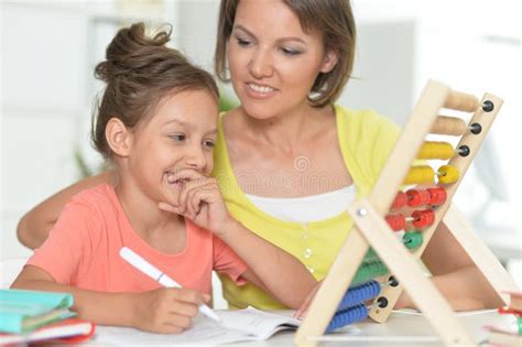 Madre Che Insegna Alla Figlia A Usare Labaco Al Chiuso Immagine Stock