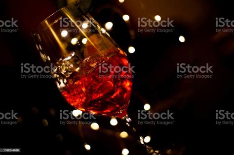 얼음 조각과 고립 된 빨간 칵테일 유리의 닫습니다 전기 조명에서 다채로운 활기찬 보케와 검은 배경입니다 0명에 대한 스톡 사진 및 기타 이미지 Istock