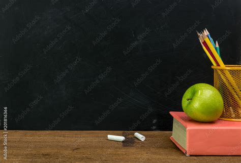 Back To School Concept Books Pencils And Green Apple Over Chalkboard