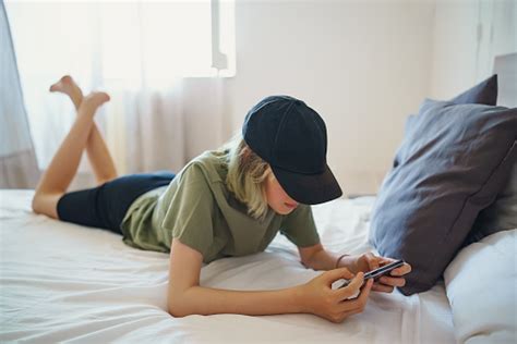 십대는 침대에 스마트 폰을 가지고 누워 있습니다 가제트 중독의 개념 사춘기 이전 어린이에 대한 스톡 사진 및 기타 이미지 사춘기 이전 어린이 십대 이동해 다님