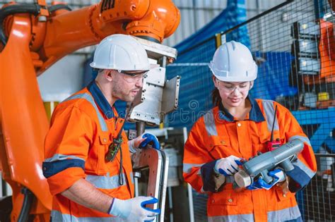 Engineer Team Worker Working Program Robot Arm Assembly Machine In Modern Metal Heavy Industry