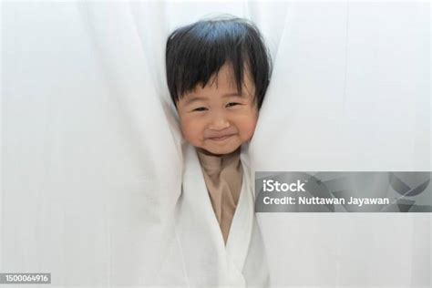 어린 아시아 아이들 어린 소녀는 손으로 눈을 가리고 벽 집 옆에 서서 숨바꼭질을 하고 집에서 즐거운 시간을 보내는 사랑스러운 아이 행복한 가족은 아이들 활동 학습과 함께