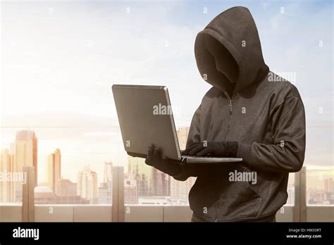 Hacker Man With Anonymous Mask Using Laptop To Hacking In The Modern