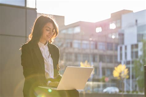 노트북에서 일하는 웃는 여성 사업가 보험 대리인은 컴퓨터에서 이메일을 확인하고 현대 사무실 센터 근처의 야외에 앉아 있습니다 계획에 대한 스톡 사진 및 기타 이미지 Istock