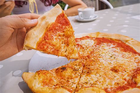 다른 요리들 사이에서 레스토랑의 테이블에 맛있는 피자 마가리타 조각을 가져 오는 손 이탈리아 요리와 패스트 푸드 카페 과거에 대한 스톡 사진 및 기타 이미지 Istock