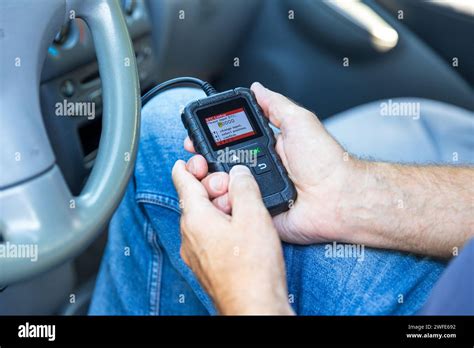 Using diagnostic car code reader to erase error codes and turn off check engine light Stock ...