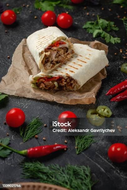 어두운 돌 테이블에 맛있는 샤와르마와 용암 타코 패스트 푸드 레스토랑 패스트 푸드의 건강한 옵션 쇠고기 고기와 야채를 곁들인 맛있는 신선한 랩 샌드위치 전통 중동 스낙