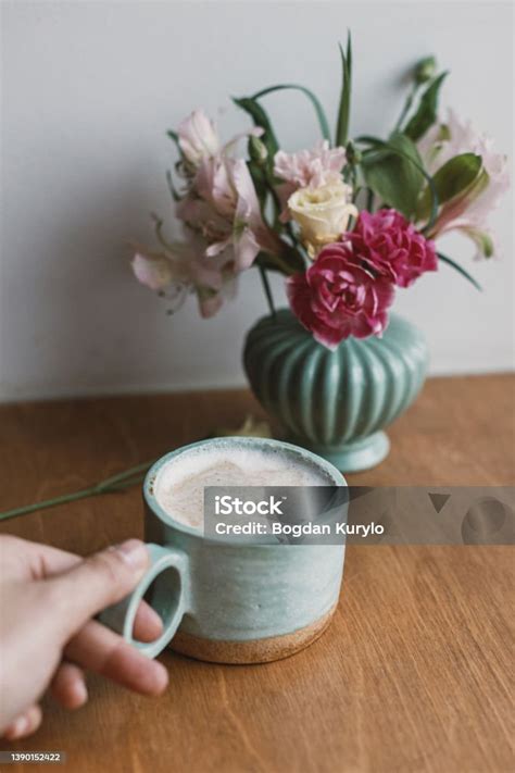 소박한 나무 배경에 커피와 꽃의 세련된 세라믹 컵을 들고 손 분홍색 꽃과 현대적인 커피 컵이있는 세라믹 꽃병 봄 아침 미학 갈색에 대한 스톡 사진 및 기타 이미지 Istock