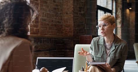 두 명의 젊은 사업가가 회의에서 컨설팅을 하고 그 중 한 명이 메모를 하고 있습니다 사진 Unsplash의 상담 이미지