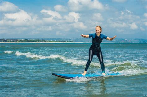 푸른 파도 함께 즐거운 젊은 여자 초급 서퍼는 작은 바다 파도에 재미가 있다 활동적인 가족 생활 사람들이 야외 물 스포츠 레슨 및 서핑 캠프 여름 방학에 수영 활동 디스코