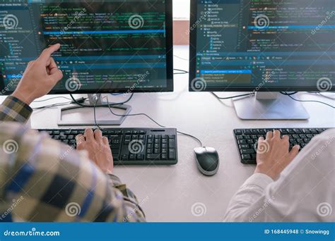 Young Startup Programmers Sitting At Desks Working On Computers Screen