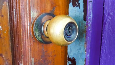Surface Worn Antique Brass Door Knobs With Surrounding Rough Texture