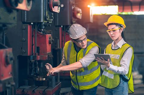 공동 작업 엔지니어 흰색 헬멧과 먼지 공장에서 노란색 헬멧은 유지 보수 주기에 의해 기계를 고정 함께 작동 20 24세에 대한