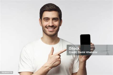 빈 스마트 폰을 들고 행복 한 젊은 남자의 초상화 카메라에서 웃 고 회색 배경에 고립 남자에 대한 스톡 사진 및 기타 이미지 남자 보여주기 전화 Istock