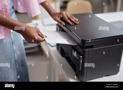 High Angle Close Up Of Printer In Office With Female Hands Inserting Paper In Scanner Office