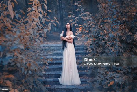 놀라운 놀라운 그리스 사랑의 여신 아프로디테 지구에 강하 했다 행복과 기쁨을 그녀의 영혼을 채우기 흰색 드레스에 긴 머리를 가진 젊은 여자는 오래 된 계단에 서 있다