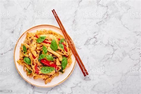 흰색 대리석 배경에 타이어 술취한 국수 또는 패드 키 마오 술취한 국수는 쌀 국수 치킨 고기 바질 소스와 야채와 태국 요리 요리입니다 태국 음식 공간을 복사합니다 맨 위