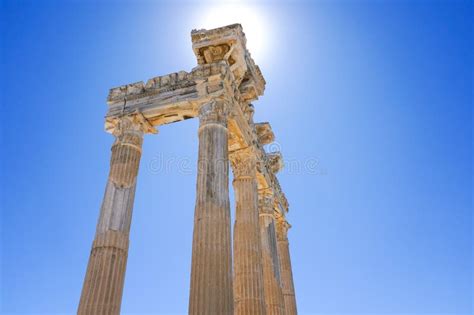 Majestic Ancient Pillars Bathed In Bright Sunlight Against A Clear Blue
