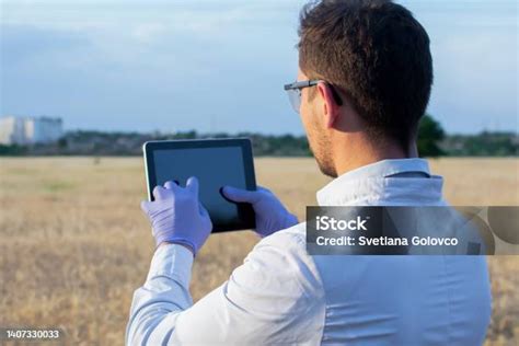 남성 농업 경제학자 생물학자 식물 연구원 농부 유전 과학자 밀 일출과 수확의 성장을 확인 문화 과학자들은 태블릿 노트북 흰색 코트와 장갑을 착용 사용 25 29세에 대한