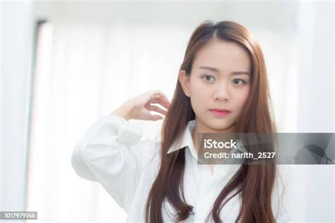 세로 아시아 젊은 여자 얼굴와 침실 화장의 여자 아름다움에 거울 보고 미소를 검사 하 고 반사 라이프 스타일과 웰빙 개념와 옷의 아름 다운 가정의 방에 대한 스톡 사진 및