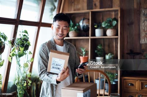 스마트폰으로 미소짓는 젊은 아시아 남성은 집에서 온라인 구매에서 배달된 소포를 받고 구매를 취소할 때까지 기다릴 수 없습니다 온라인 쇼핑 즐거운 고객 쇼핑 경험 온라인
