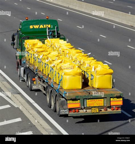 Aerial View Of Articulated Hgv Lorry Truck On Motorway Trailer Loaded With Large Yellow Fibc