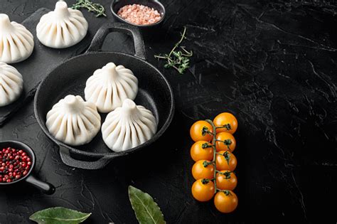 황갈색 또는 맨티 만두 인기있는 아시아 요리 프라이주 철 팬에 검은 돌 배경에 상단 보기 플랫 레이 텍스트복사 공간 0명에 대한