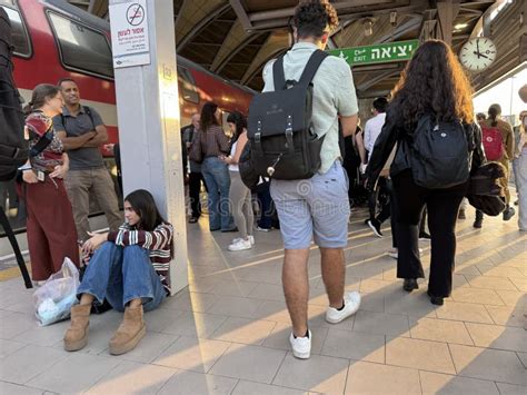 Busy Train Station Platform Scene With Travelers And A Girl Sitting On